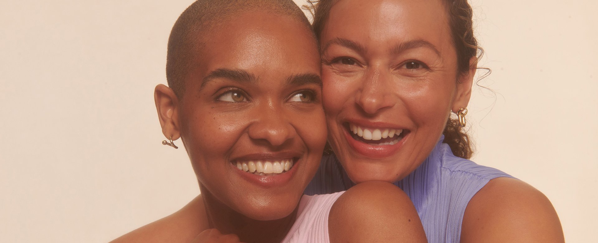 Two women with clean makeup looks smiling